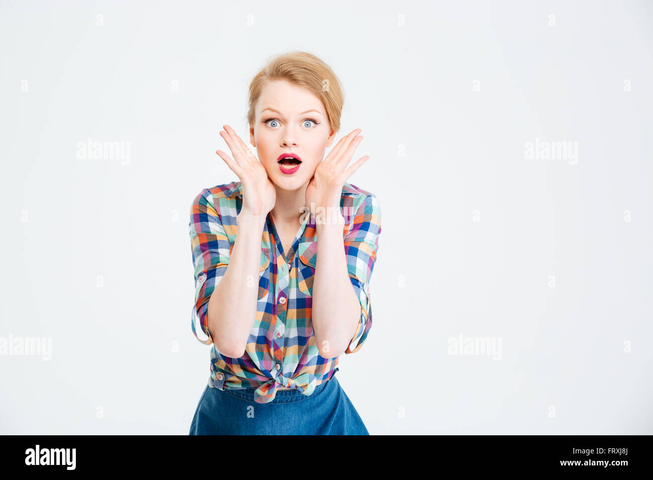 Amazed young woman looking at camera isolated on a white background ...