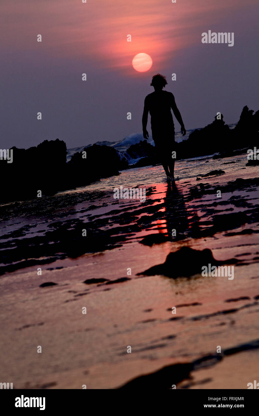 Man walking along beach at sunset hi-res stock photography and images ...