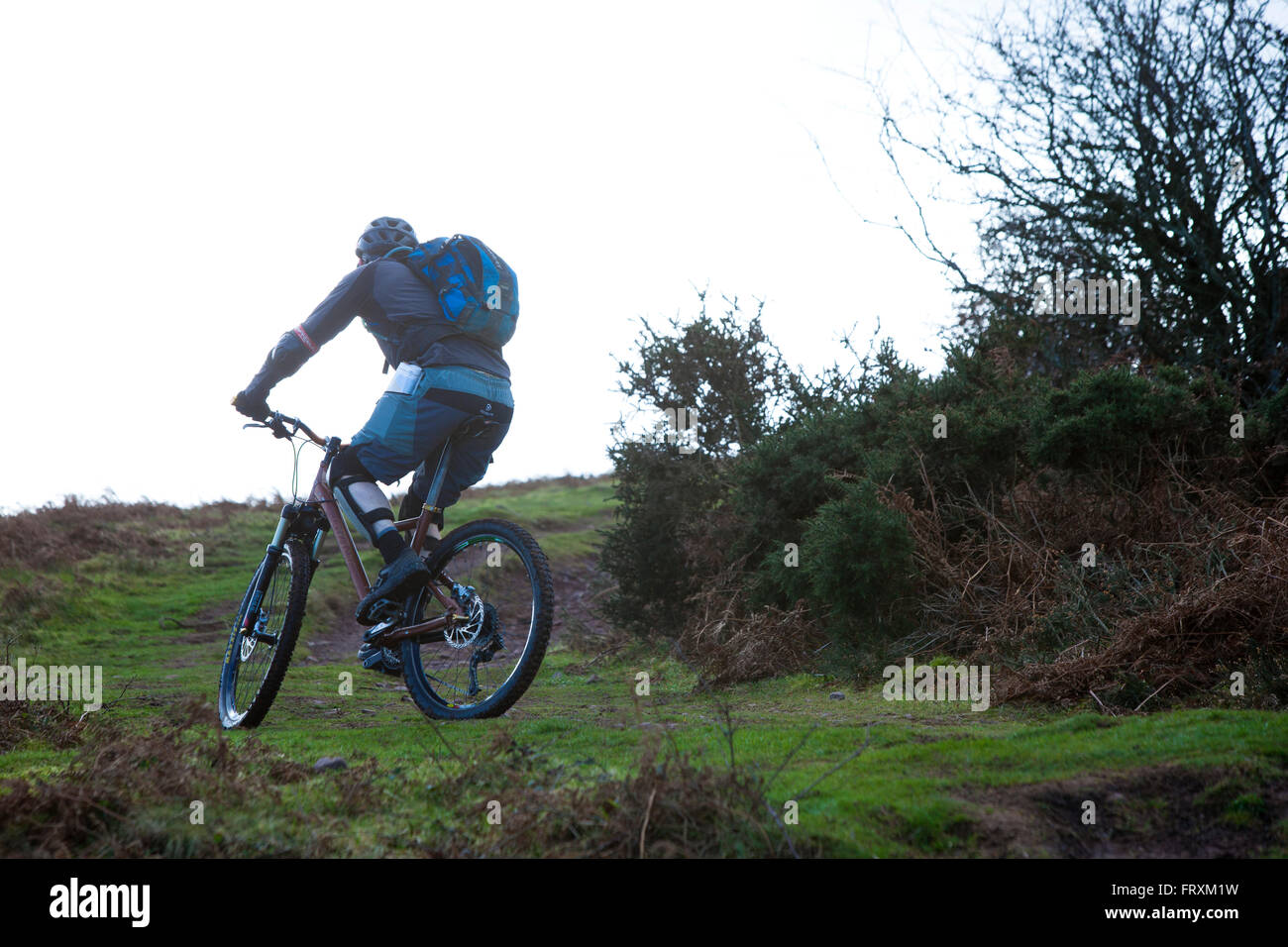 A mountain biker or cyclist battles up a hill on the south west coastal ...