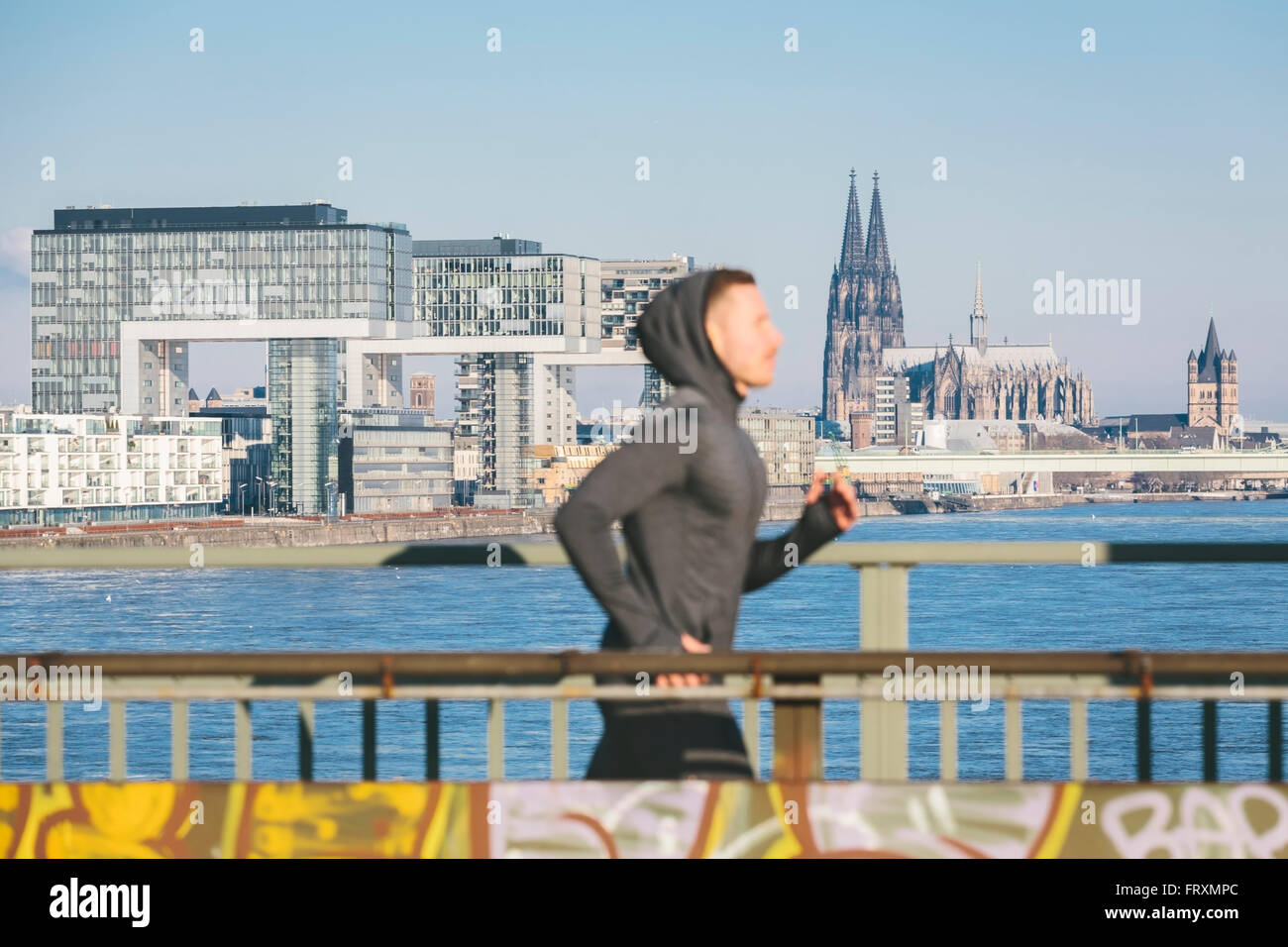 Germany, Cologne, Young man running at the riverside Stock Photo - Alamy