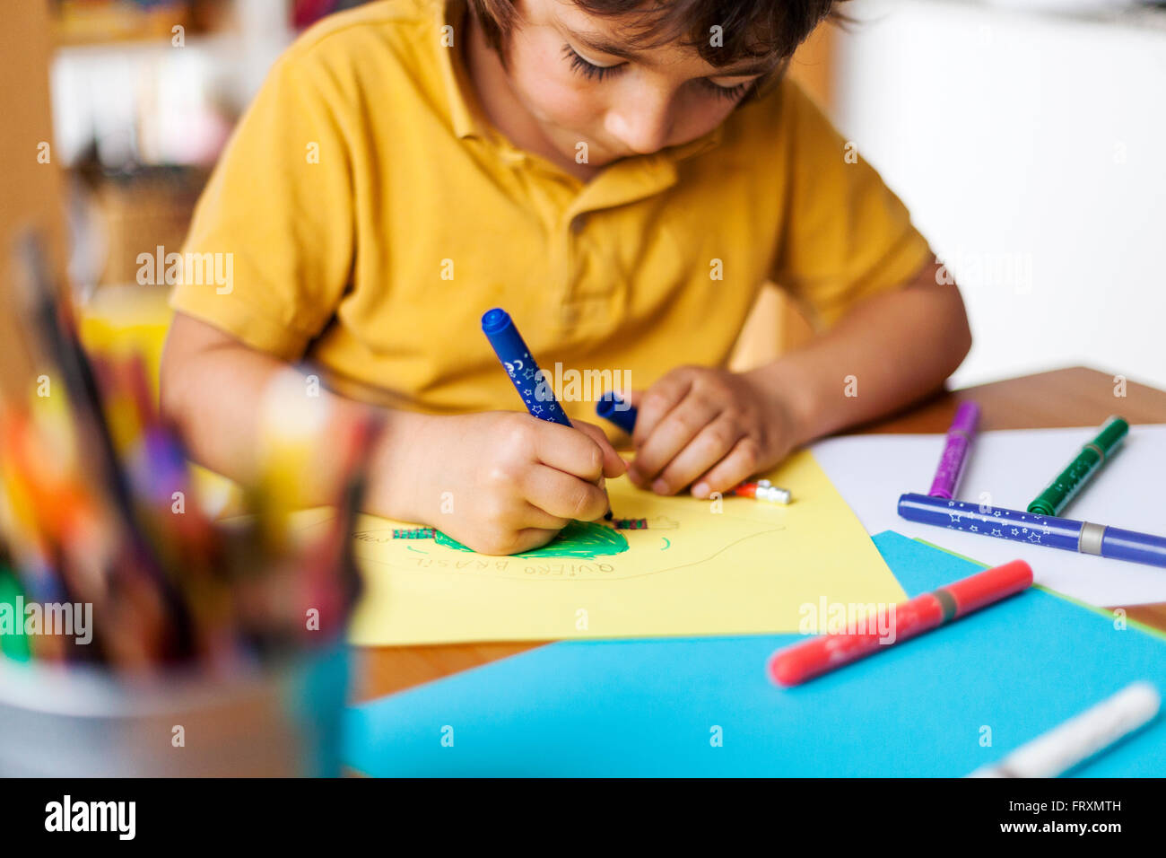 Little boy drawing on yellow paper Stock Photo - Alamy