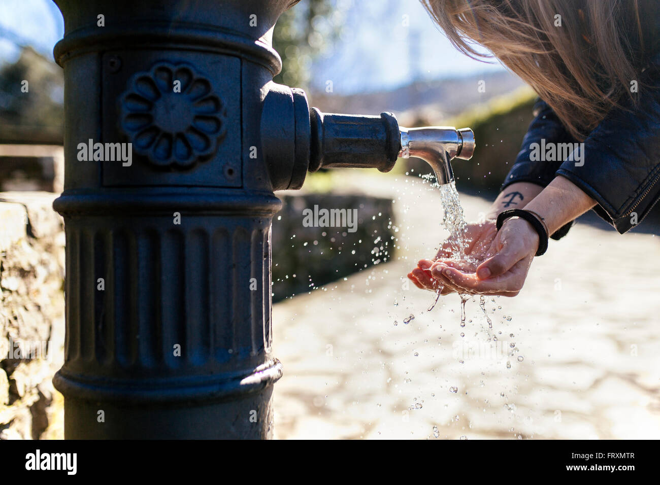 Young woman washing hands at a well Stock Photo - Alamy