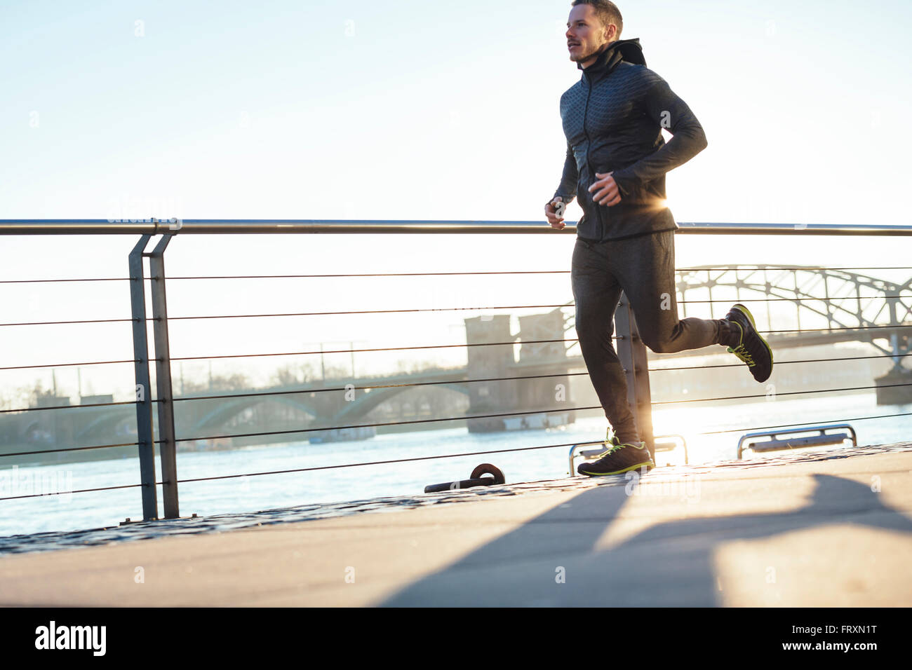 Germany, Cologne, Young man running at the riverside Stock Photo - Alamy