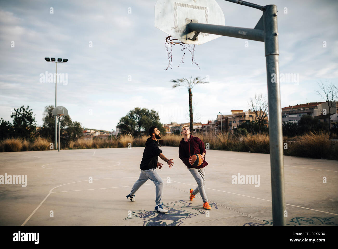 Two young men playing basketball on an outdoor court Stock Photo - Alamy