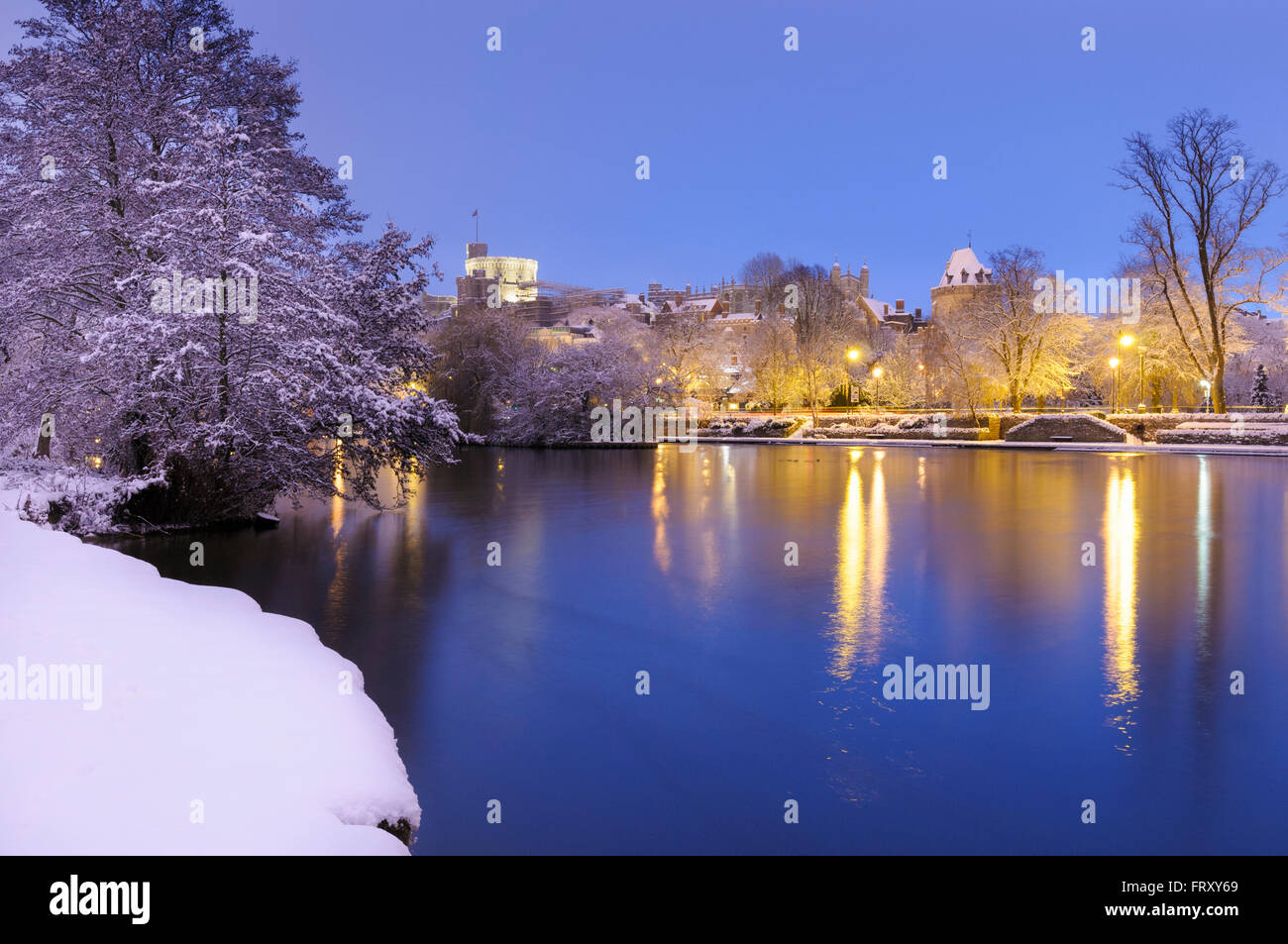 Night falls on a snow covered Windsor castle and the river Thames Stock ...