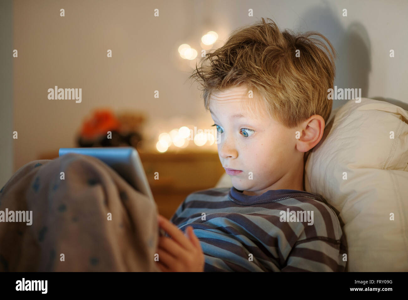 Kid using ipad in bed hi-res stock photography and images - Alamy