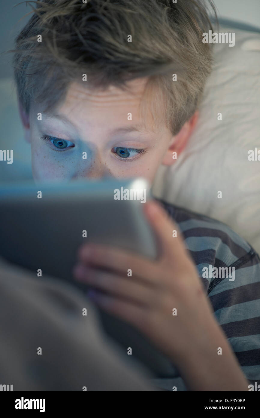 Kid using ipad in bed hi-res stock photography and images - Alamy