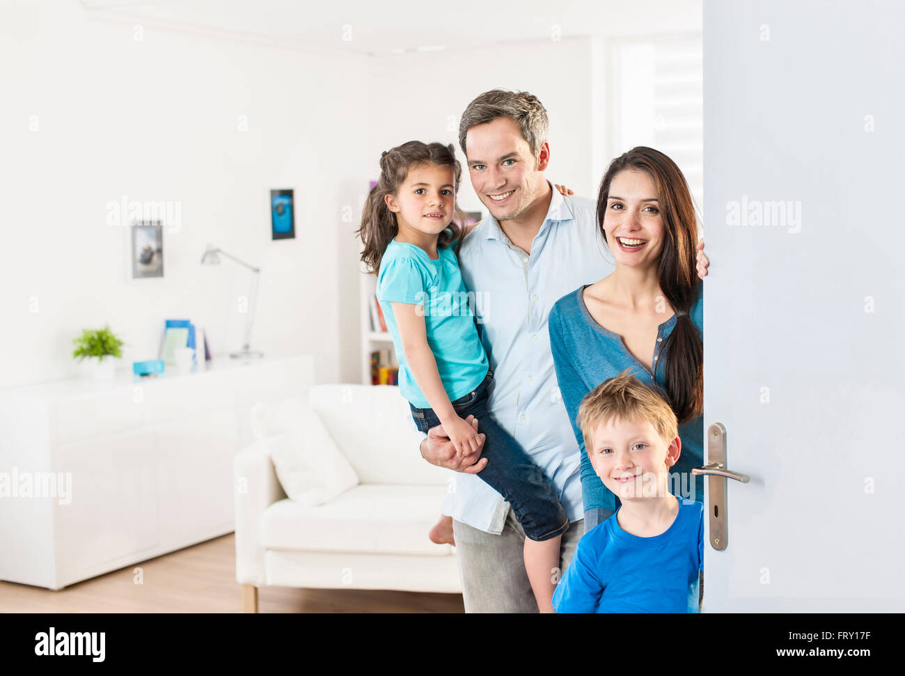 Family standing at front door to invite people at home Stock Photo - Alamy