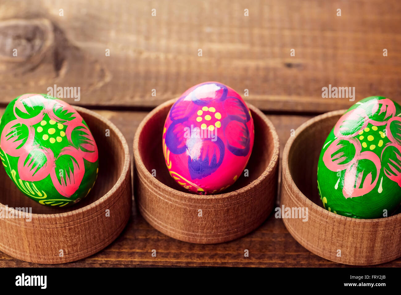 Beautiful background with painted Easter eggs in little wooden nests ...