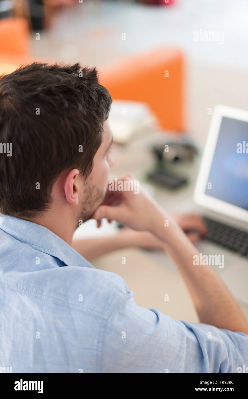rear view of a man examining his computer's screen Stock Photo - Alamy