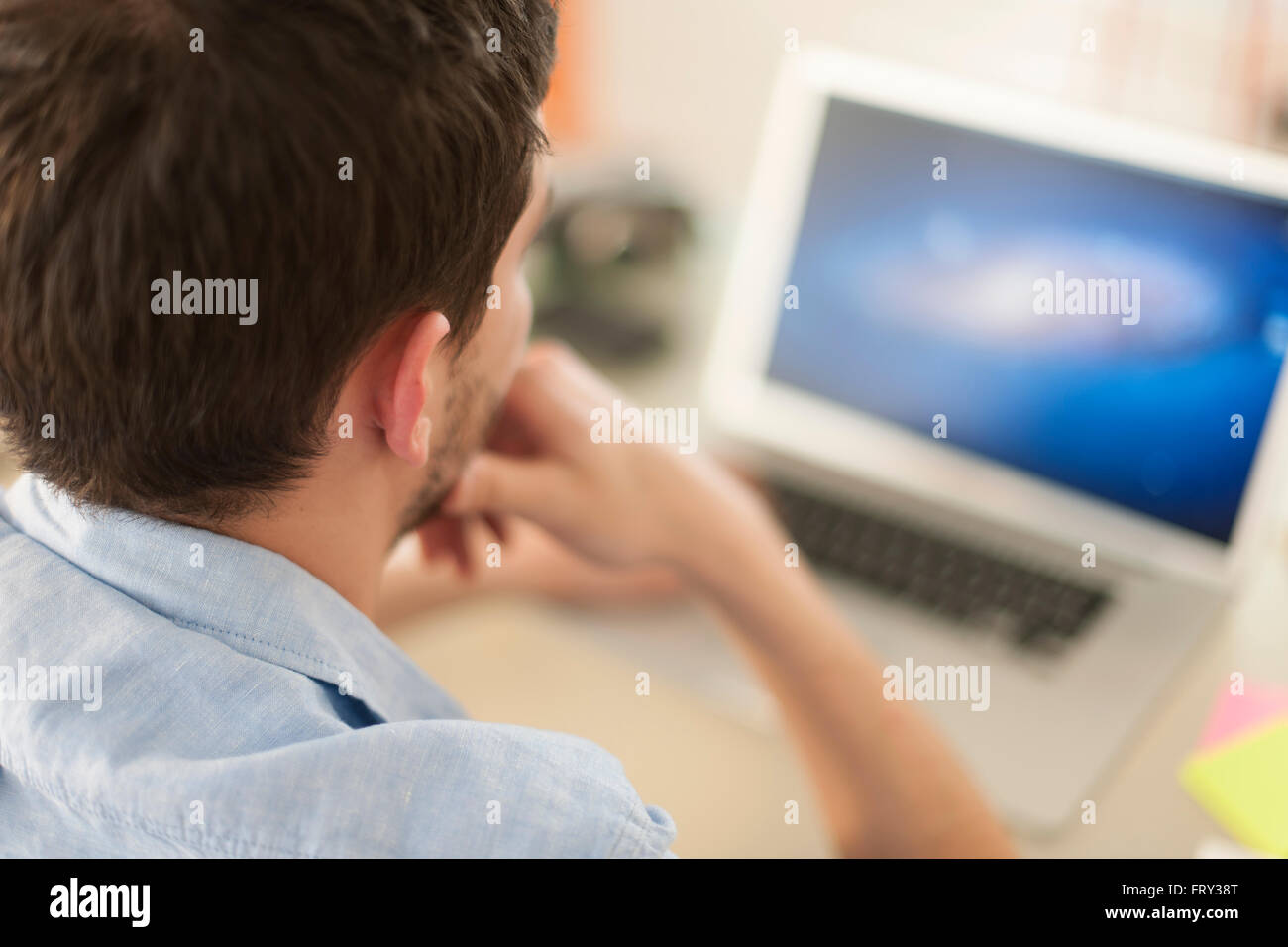 rear view of a man examining his computer's screen Stock Photo - Alamy