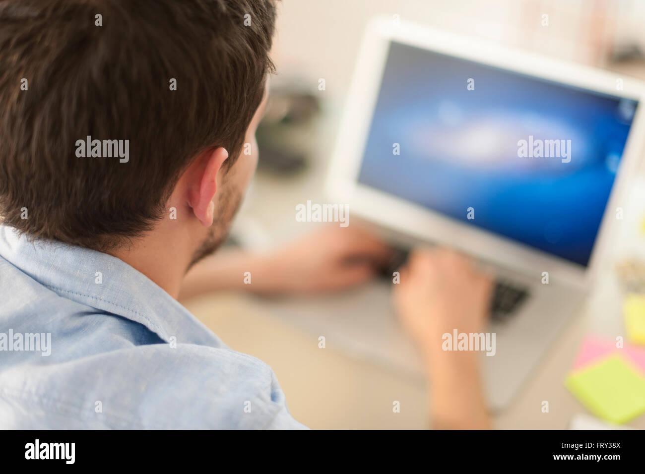 rear view of a man examining his computer's screen Stock Photo - Alamy