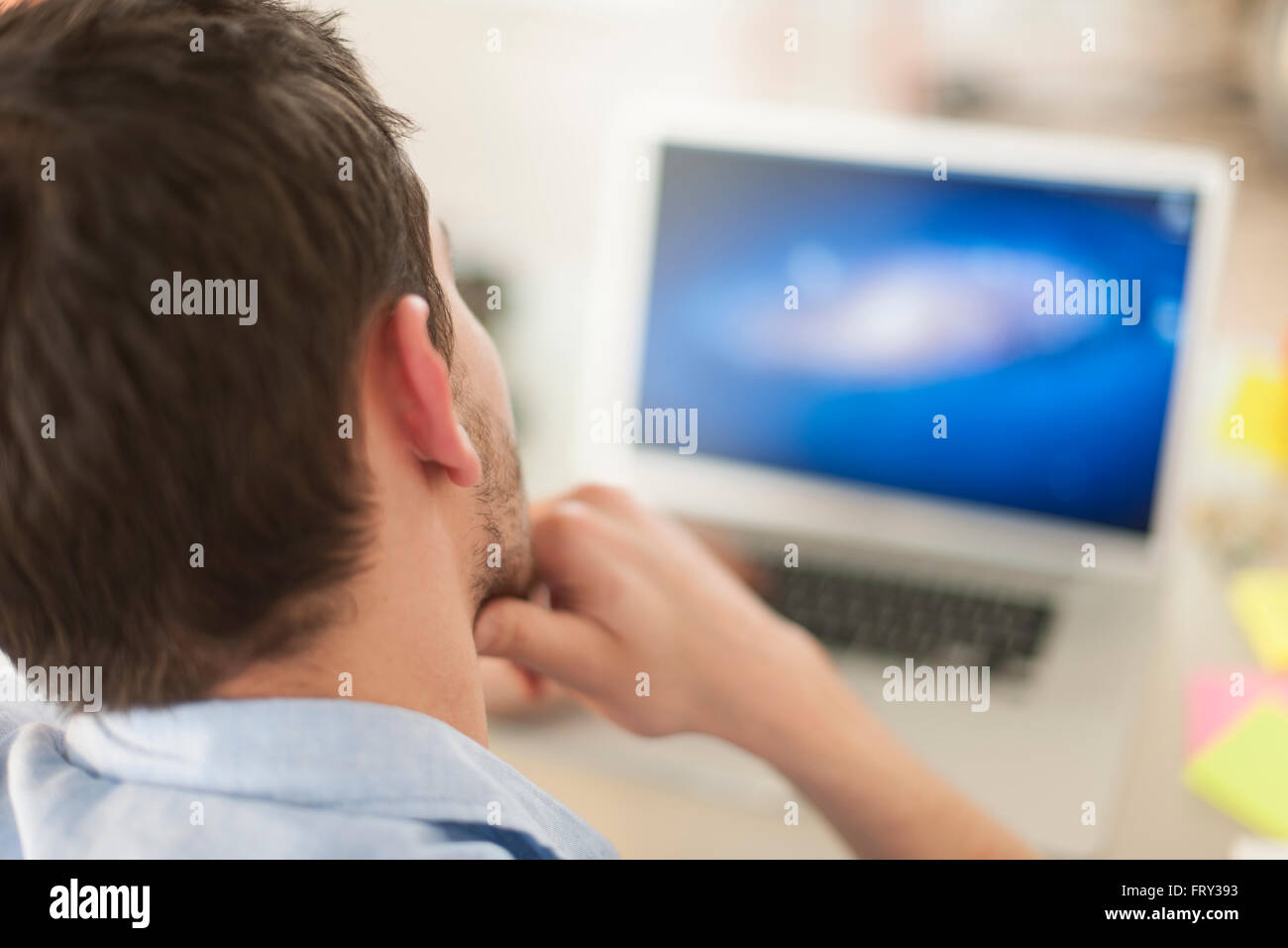 rear view of a man examining his computer's screen Stock Photo - Alamy