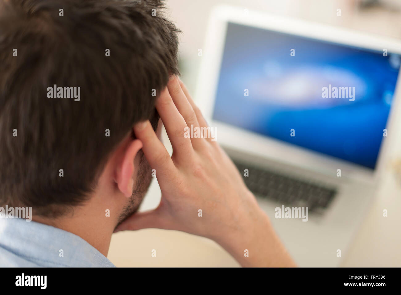 rear view of a man examining his computer's screen Stock Photo - Alamy