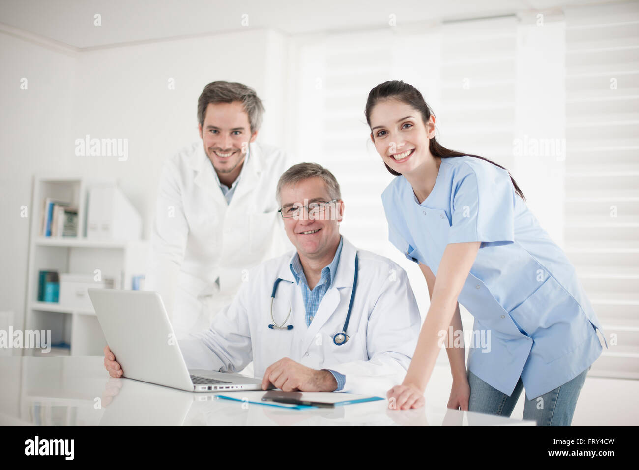 medical team discussing around a computer Stock Photo - Alamy