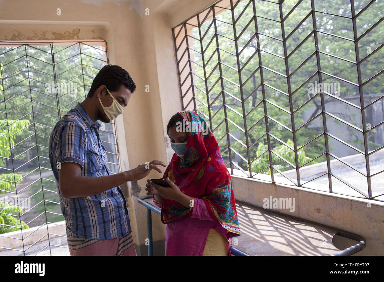 Dhaka, Dhaka, Bangladesh. 24th Mar, 2016. A TB patient and his relative play with a cell phone ...