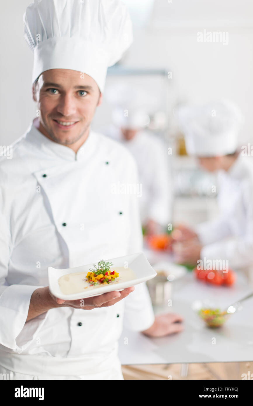 chef presenting a dish with his team in background Stock Photo - Alamy
