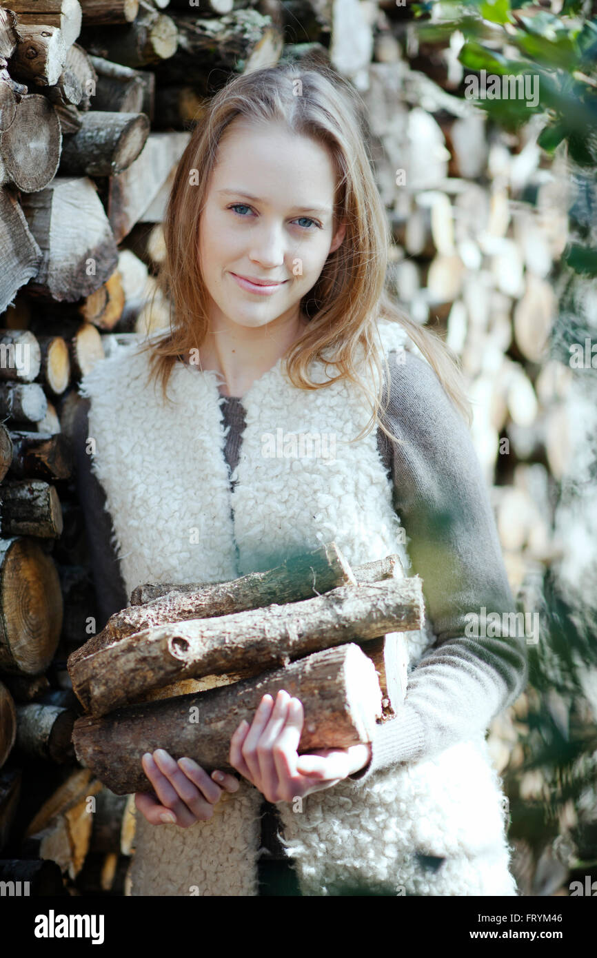 beautiful young woman outside carrying logs in his arms Stock Photo - Alamy
