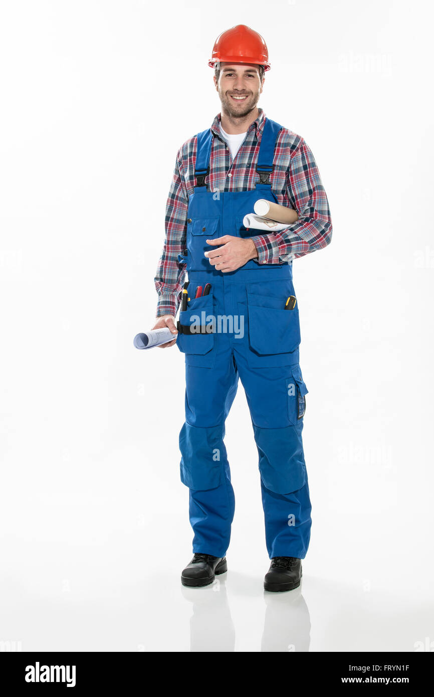 a craftsman in workwear clothing with an hardhat and blueprints in arm ...