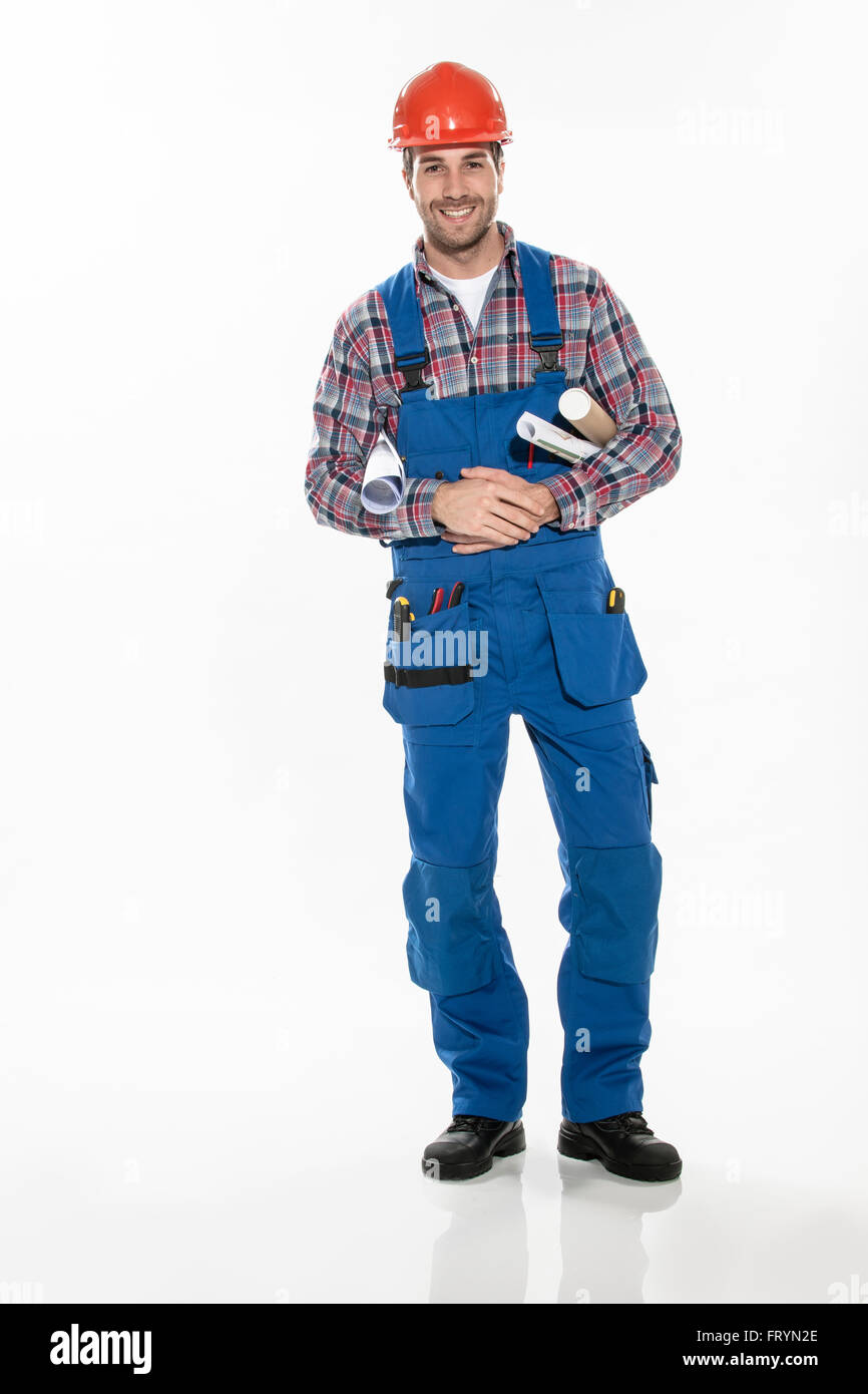 a craftsman in workwear clothing with an hardhat and blueprints in arm ...
