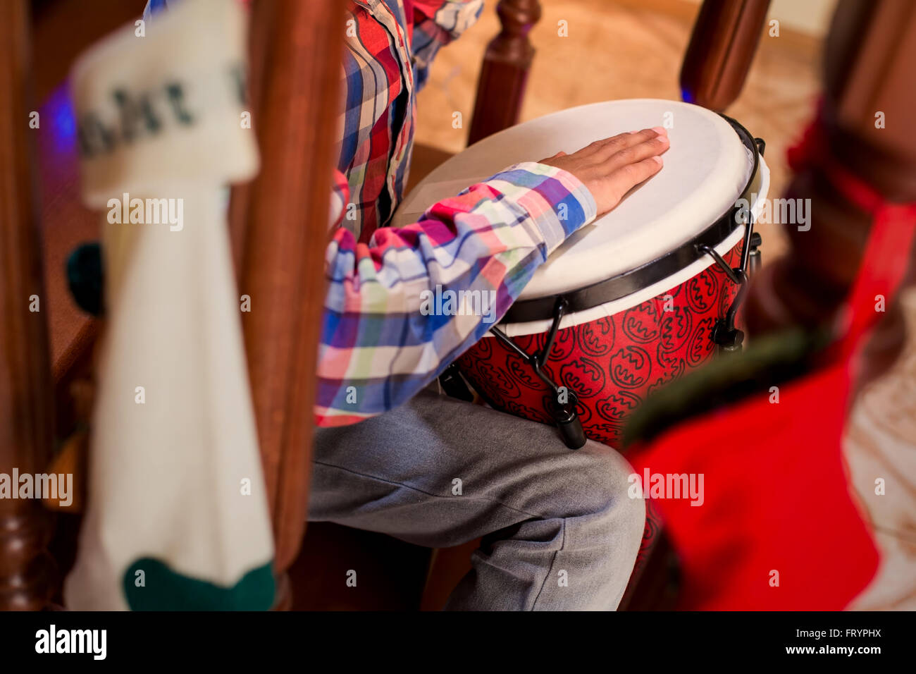 Mulatto child playing percussion drum. Boy plays djembe on stairs ...