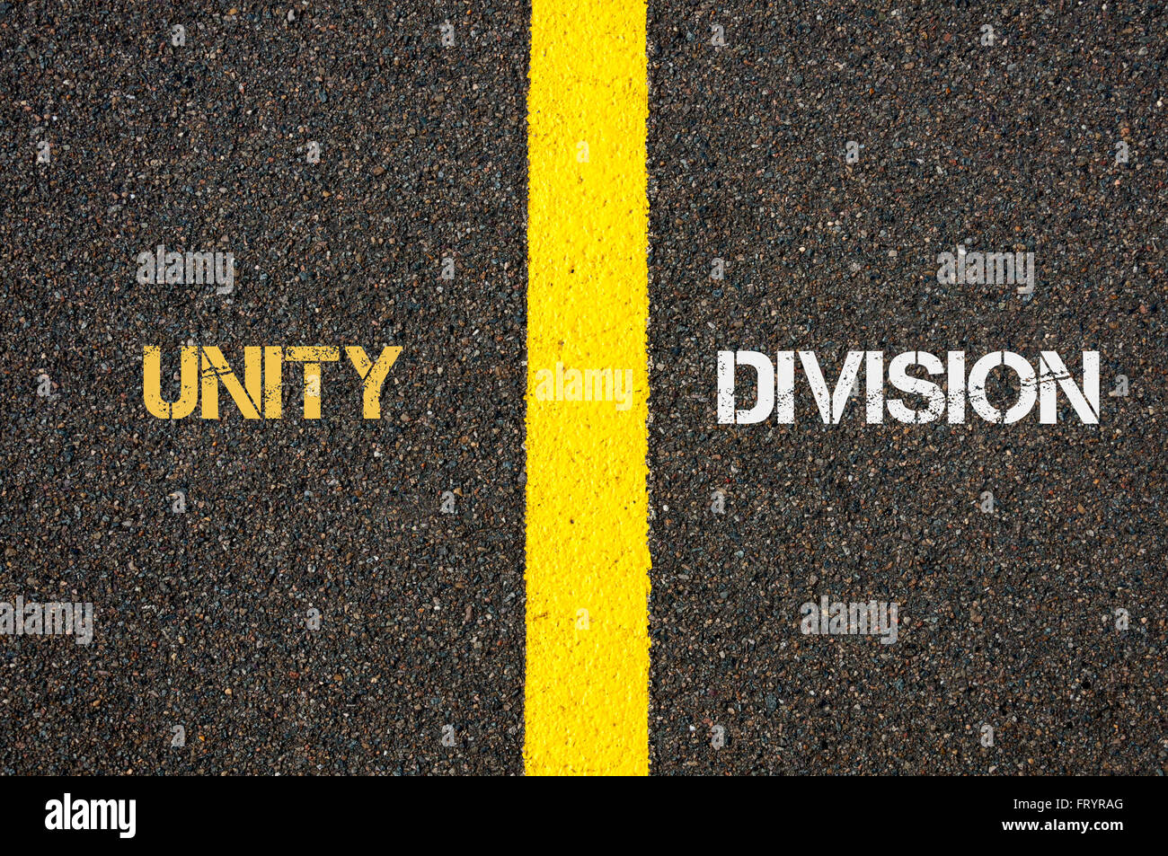 Antonym concept of UNITY versus DIVISION written over tarmac, road ...