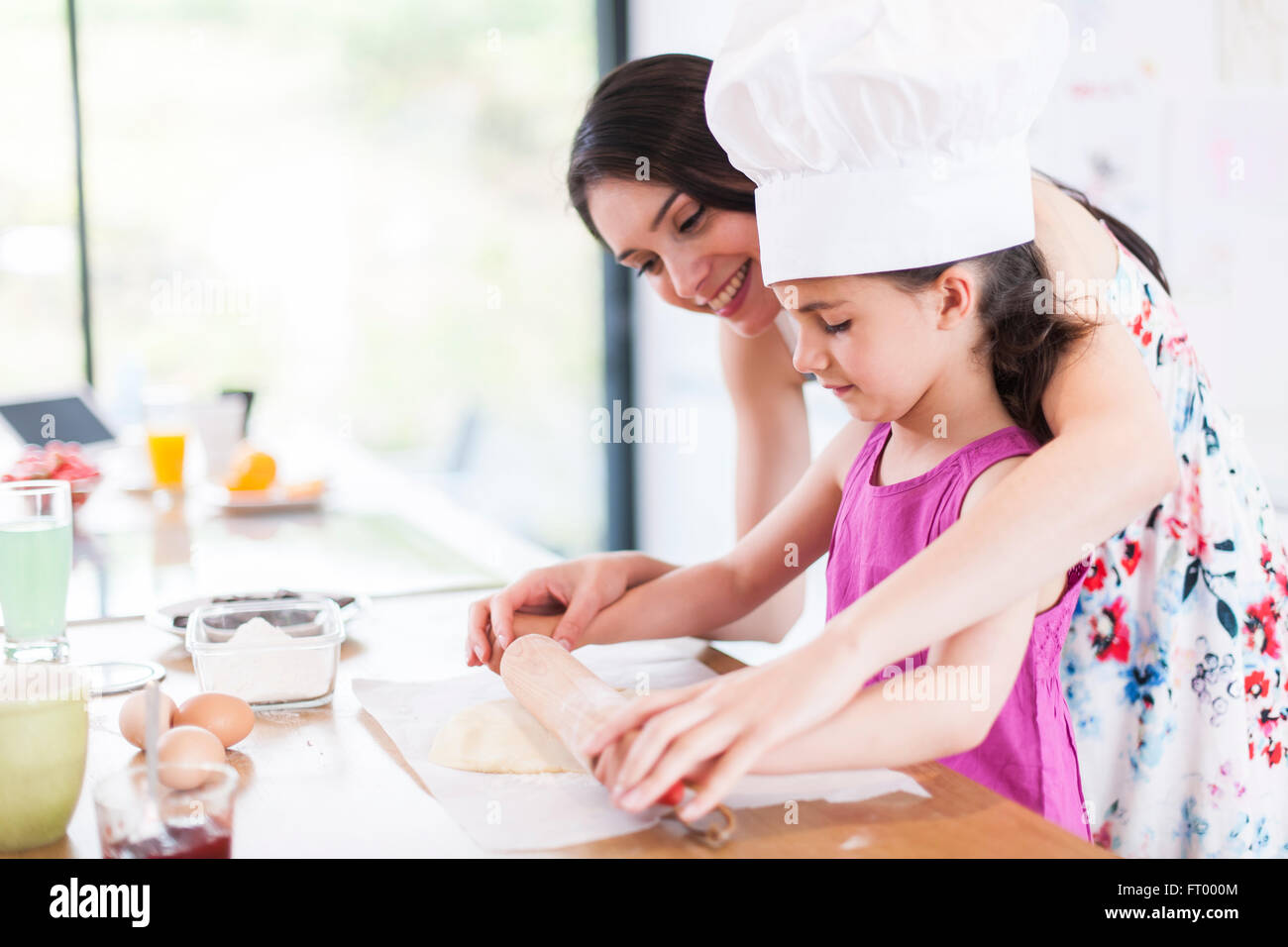 little girl helping her mother prepare a cake Stock Photo - Alamy