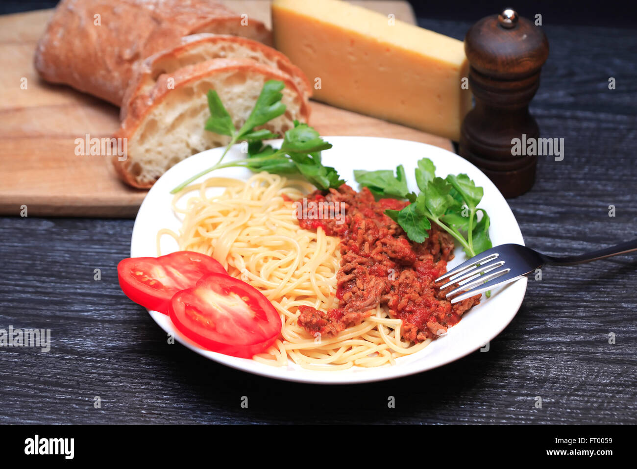 Traditional Italian supper. Plate with Bolognese pasta near fork and ...