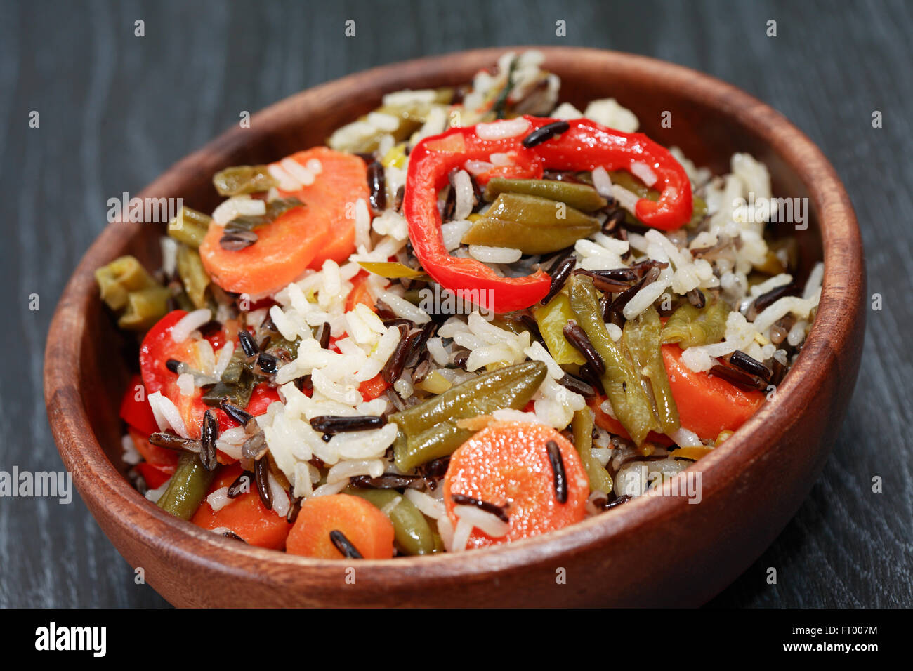 Nice wooden bowl fool of boiled rice with vegetables Stock Photo - Alamy