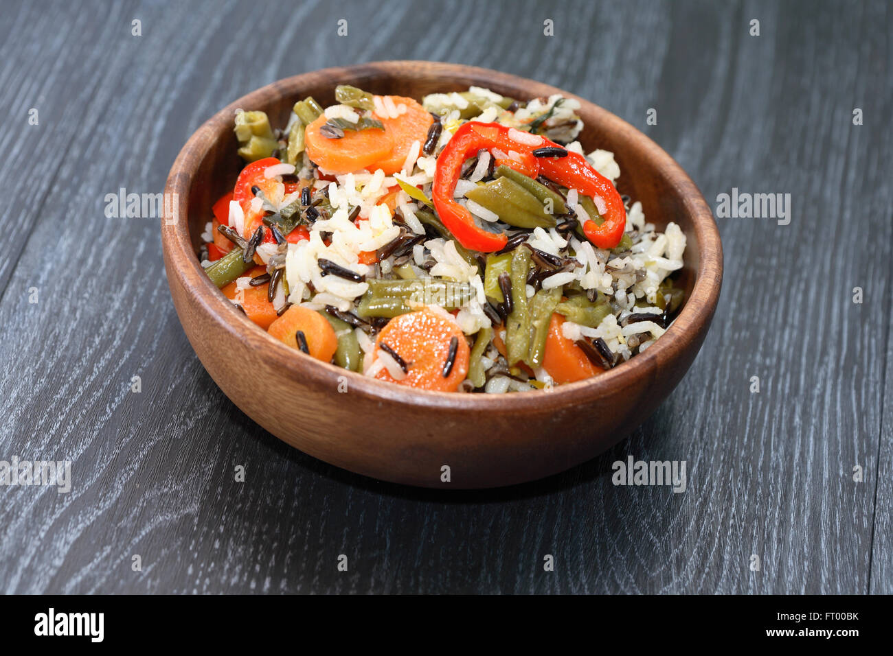 Nice wooden bowl fool of boiled rice with vegetables Stock Photo - Alamy