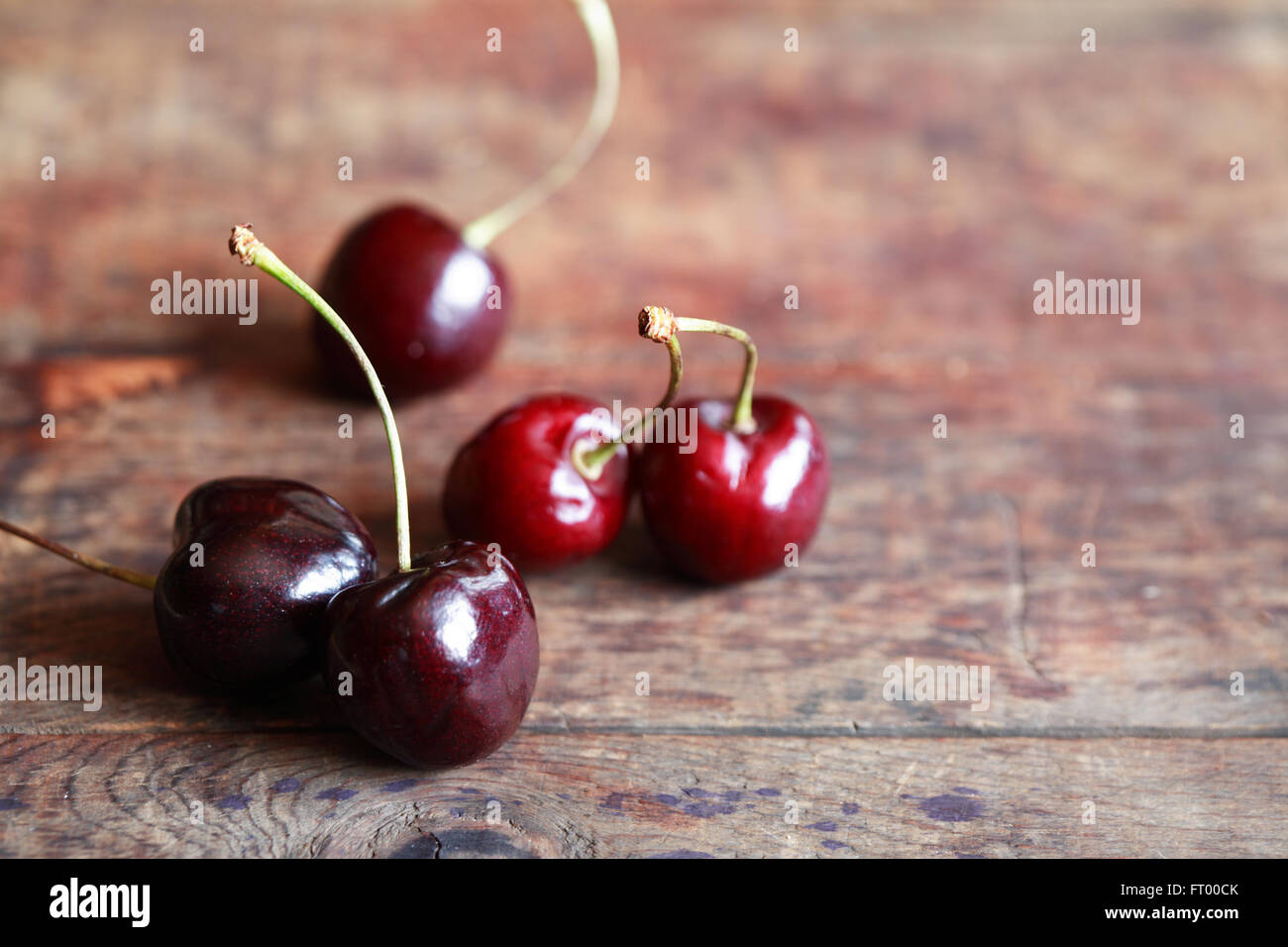 Few freshness cherries on old wooden board Stock Photo - Alamy