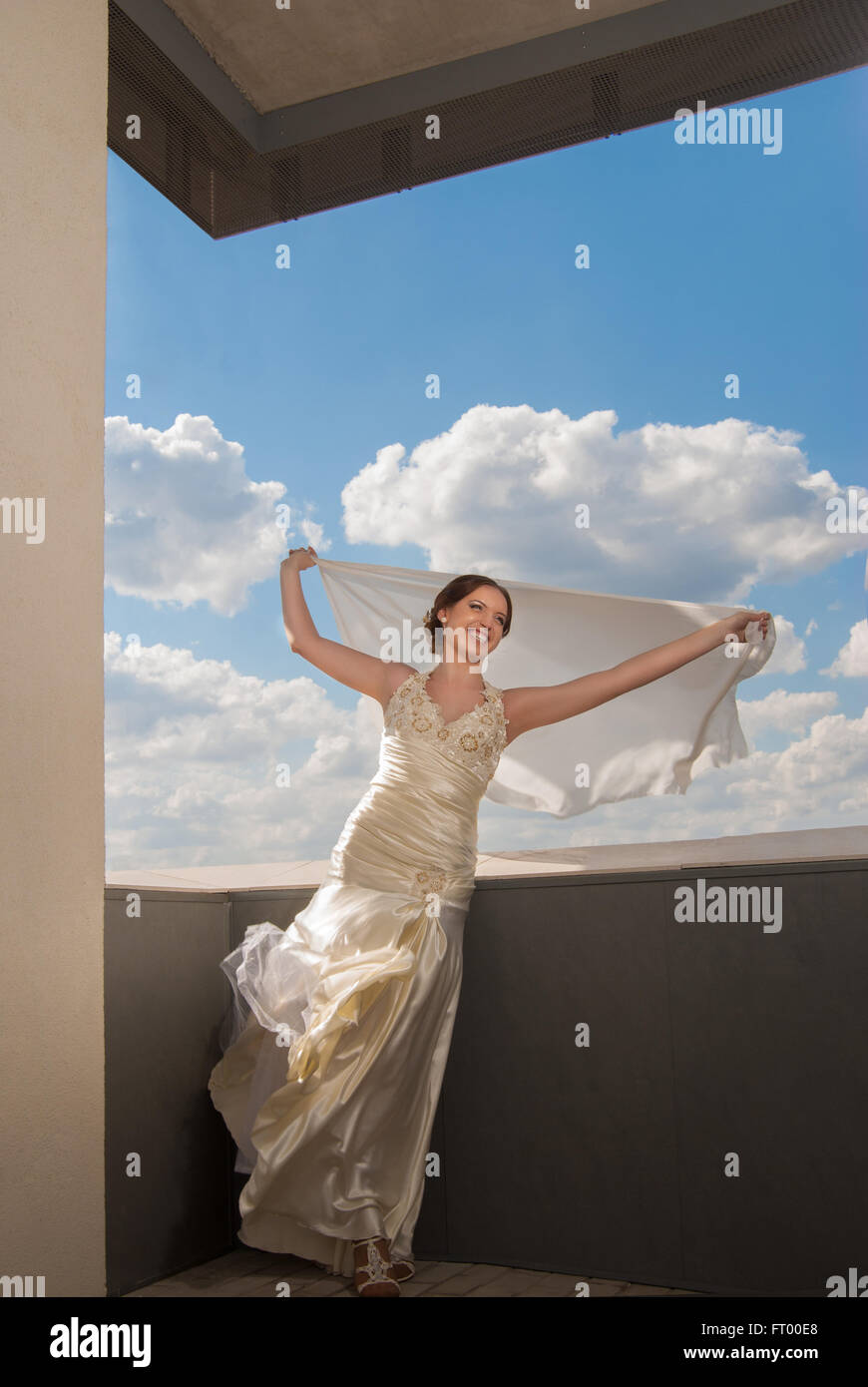 Happy beautiful bride with flying fabric over sky Stock Photo - Alamy