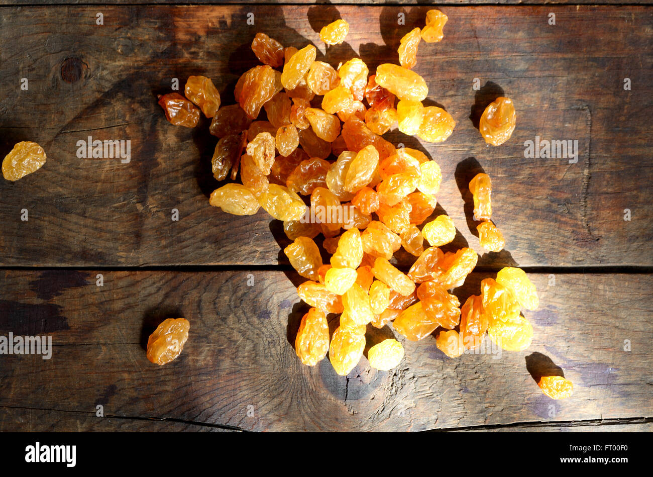 Closeup of dried raisin on nice old wooden background under sunbeam ...