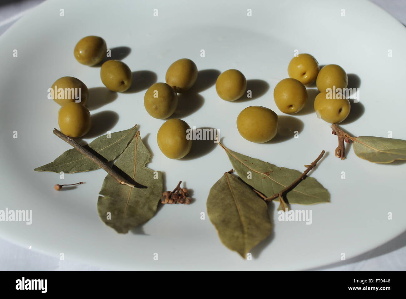 green olives on laurel leaves aroma and spicy ingredient for sauce ...