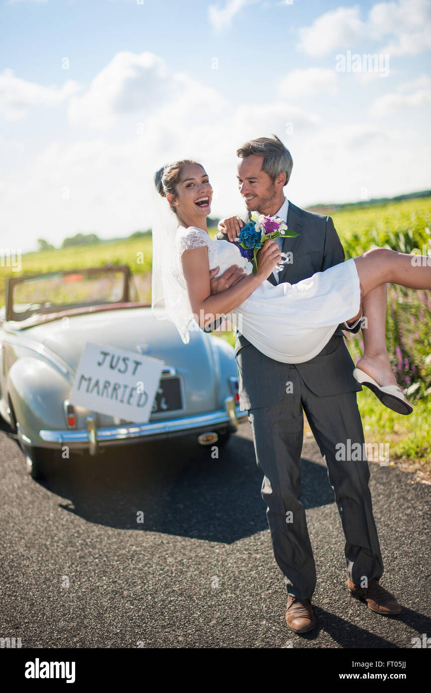Groom carrying bride in arms hi-res stock photography and images - Alamy