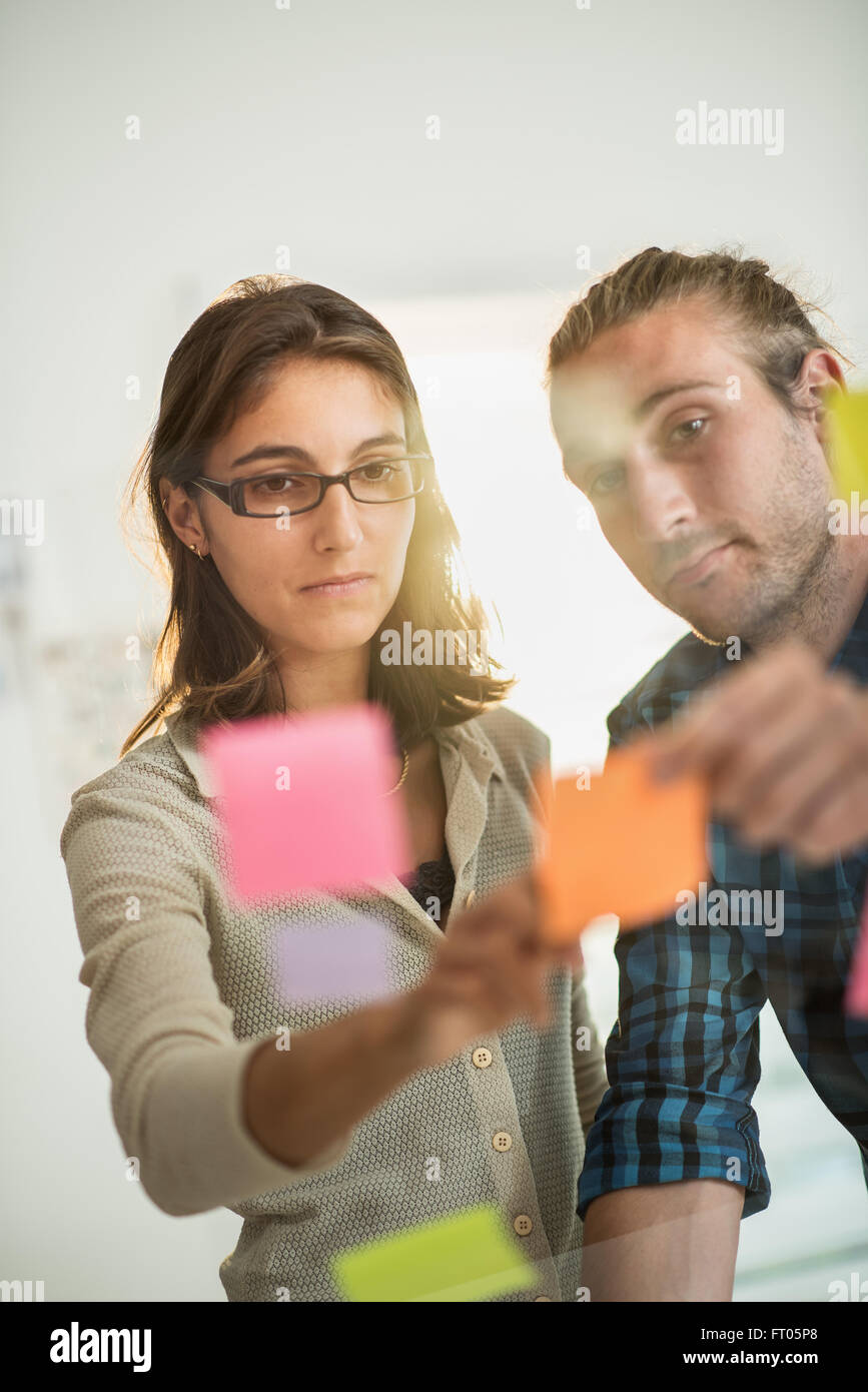Shot through glass windows. Creative team standing in a luminous office ...