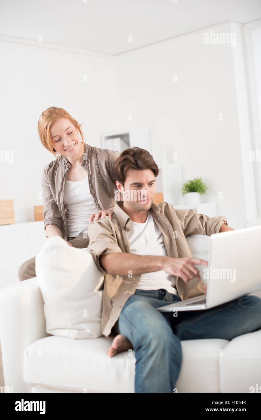 happy young couple using computer at home Stock Photo - Alamy