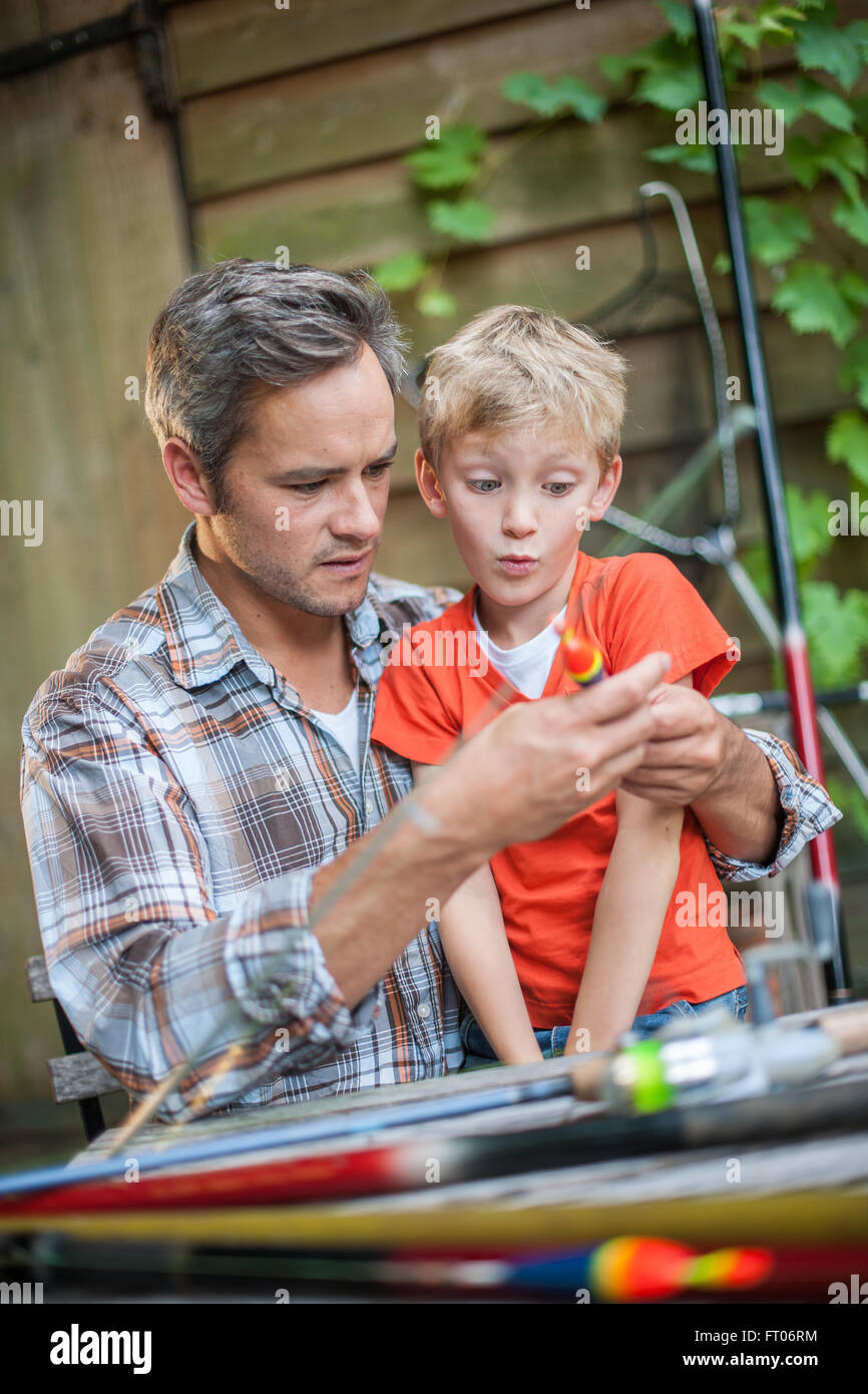 Portait of father and son preparing the hook for their fishing trip ...