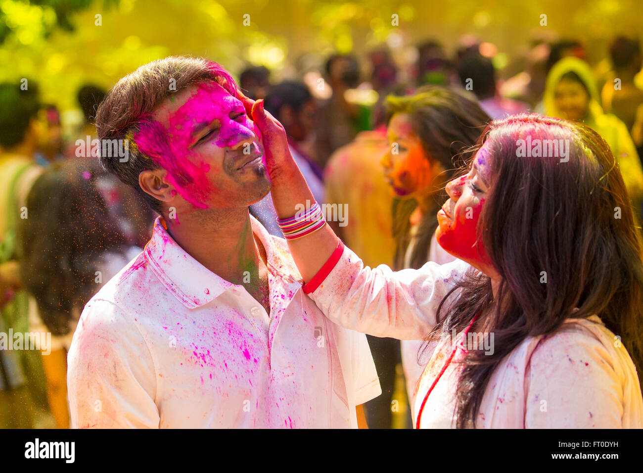 A woman smeared with colored powder, takes part in celebrations of the ...