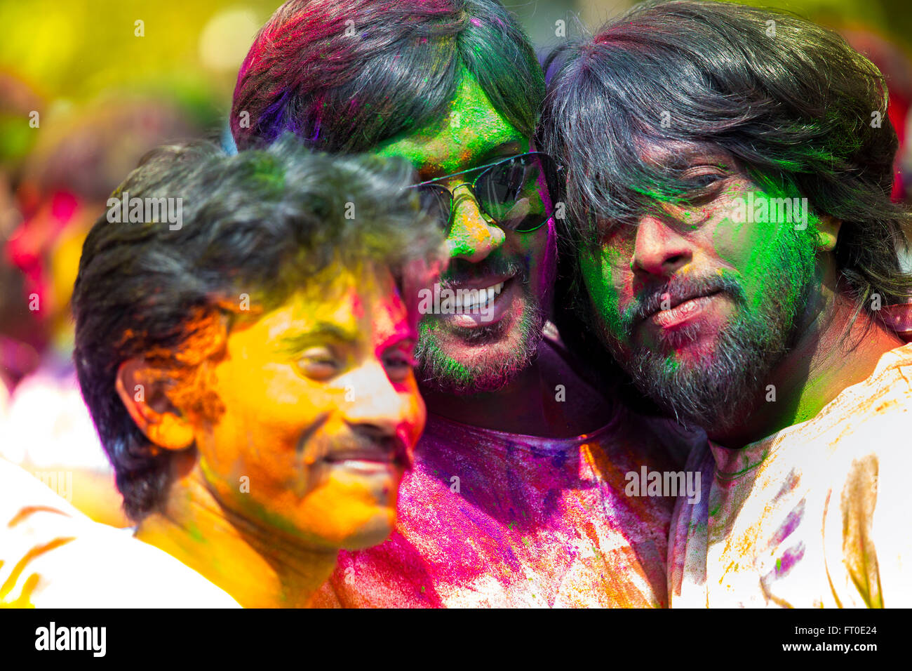 A woman smeared with colored powder, takes part in celebrations of the ...