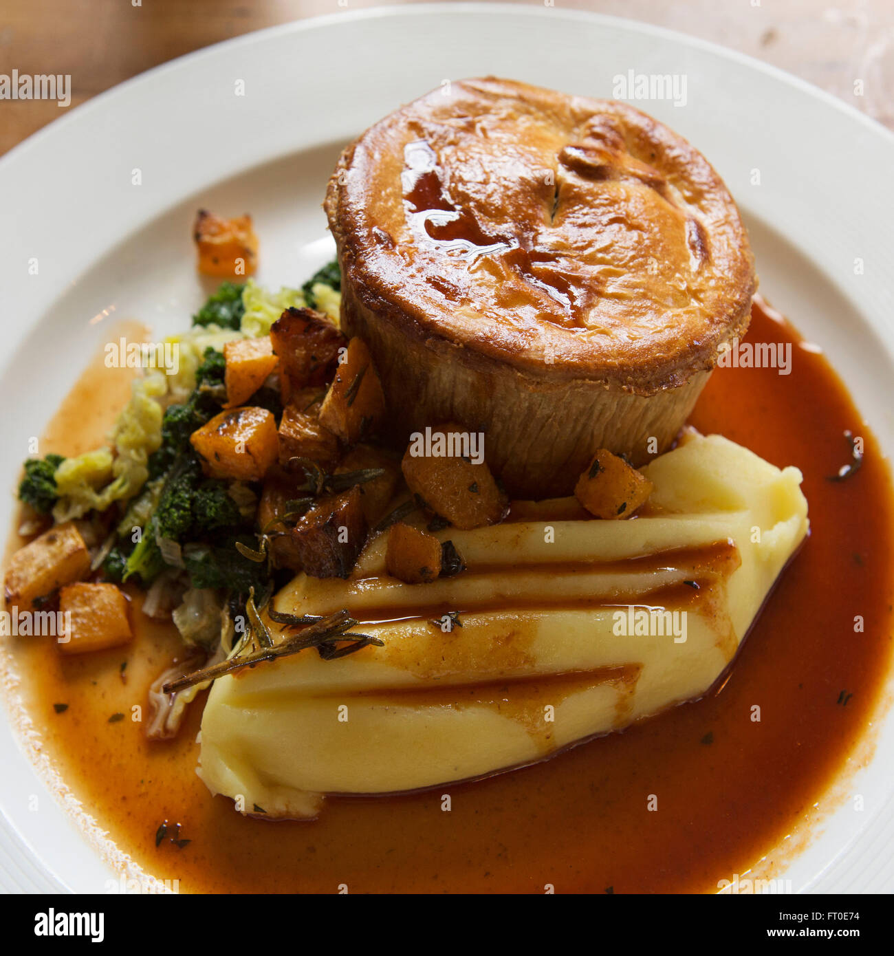 Venison pie served with mashed potatoe and seasonal vegetables in ...