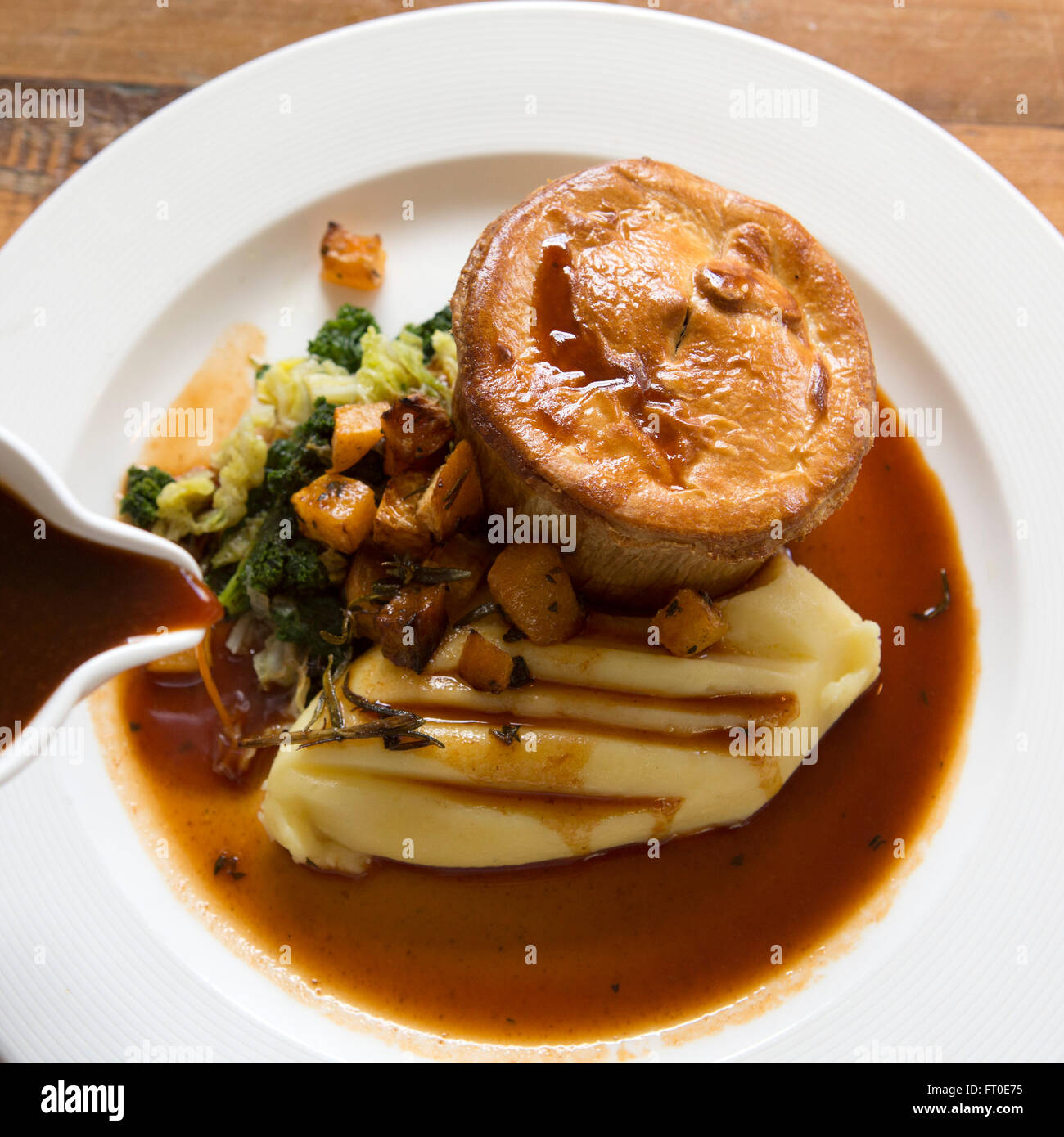 Venison pie served with mashed potatoe and seasonal vegetables in ...