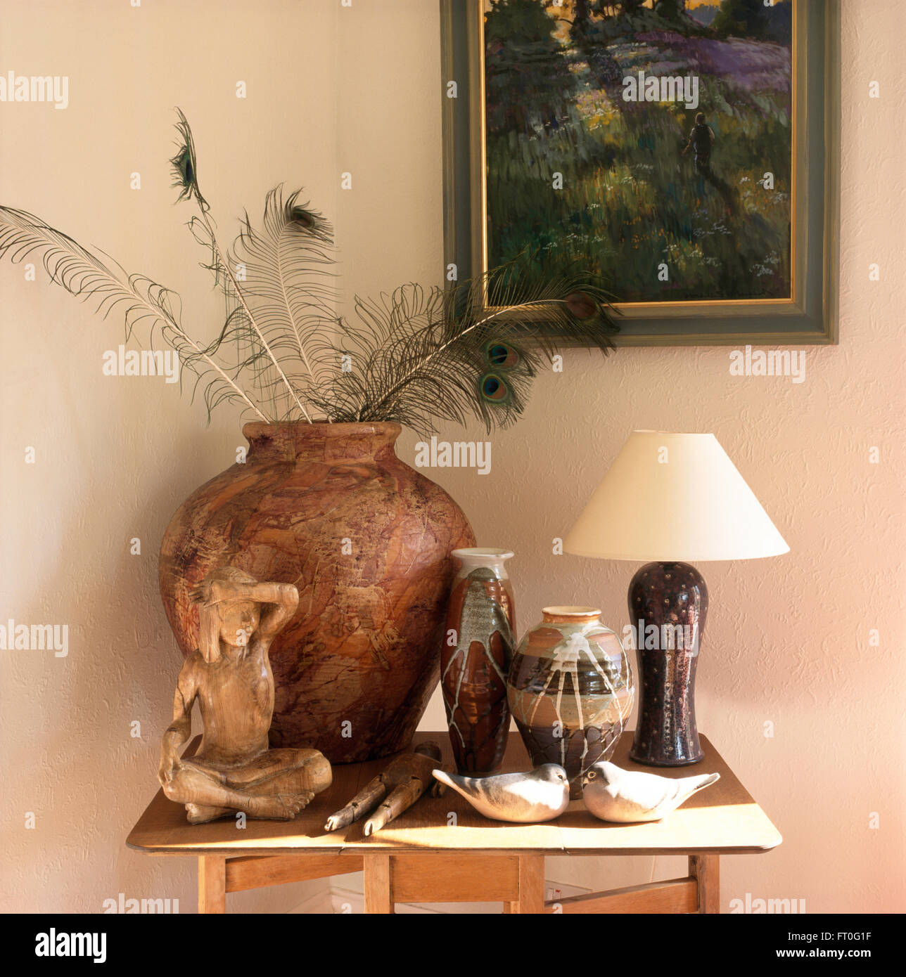 Collection of vases and a large pot with peacock feather on a small ...