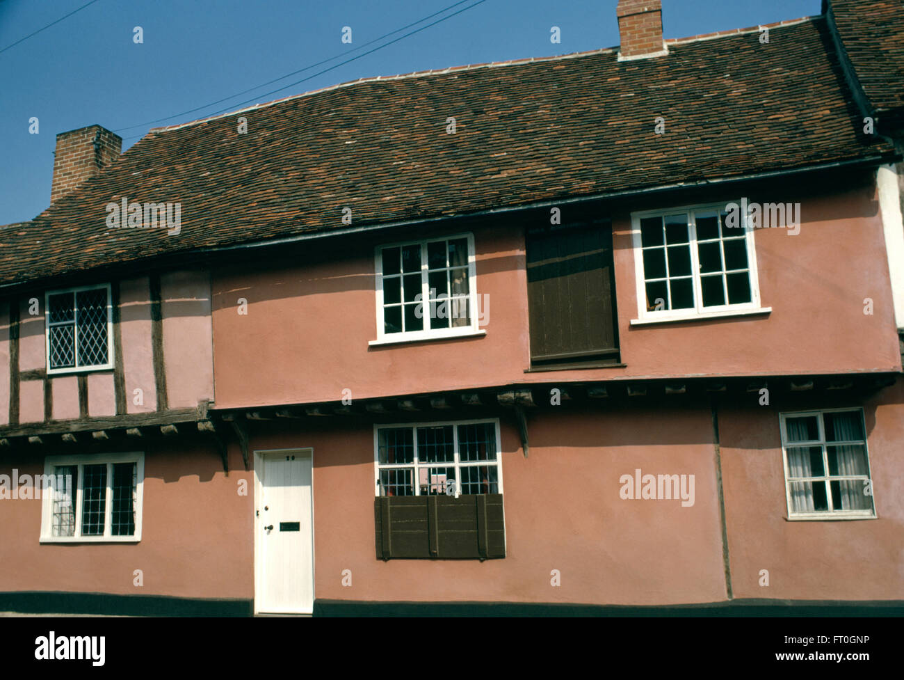 Exterior of a traditional pink painted Suffolk house with a white front ...