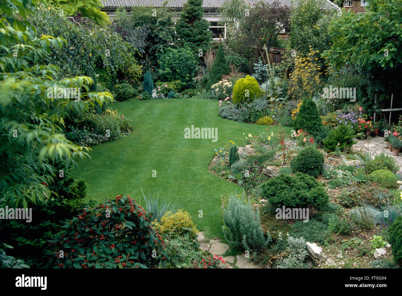 Birds-eye view of a newly mown curved lawn edged with rockery borders ...