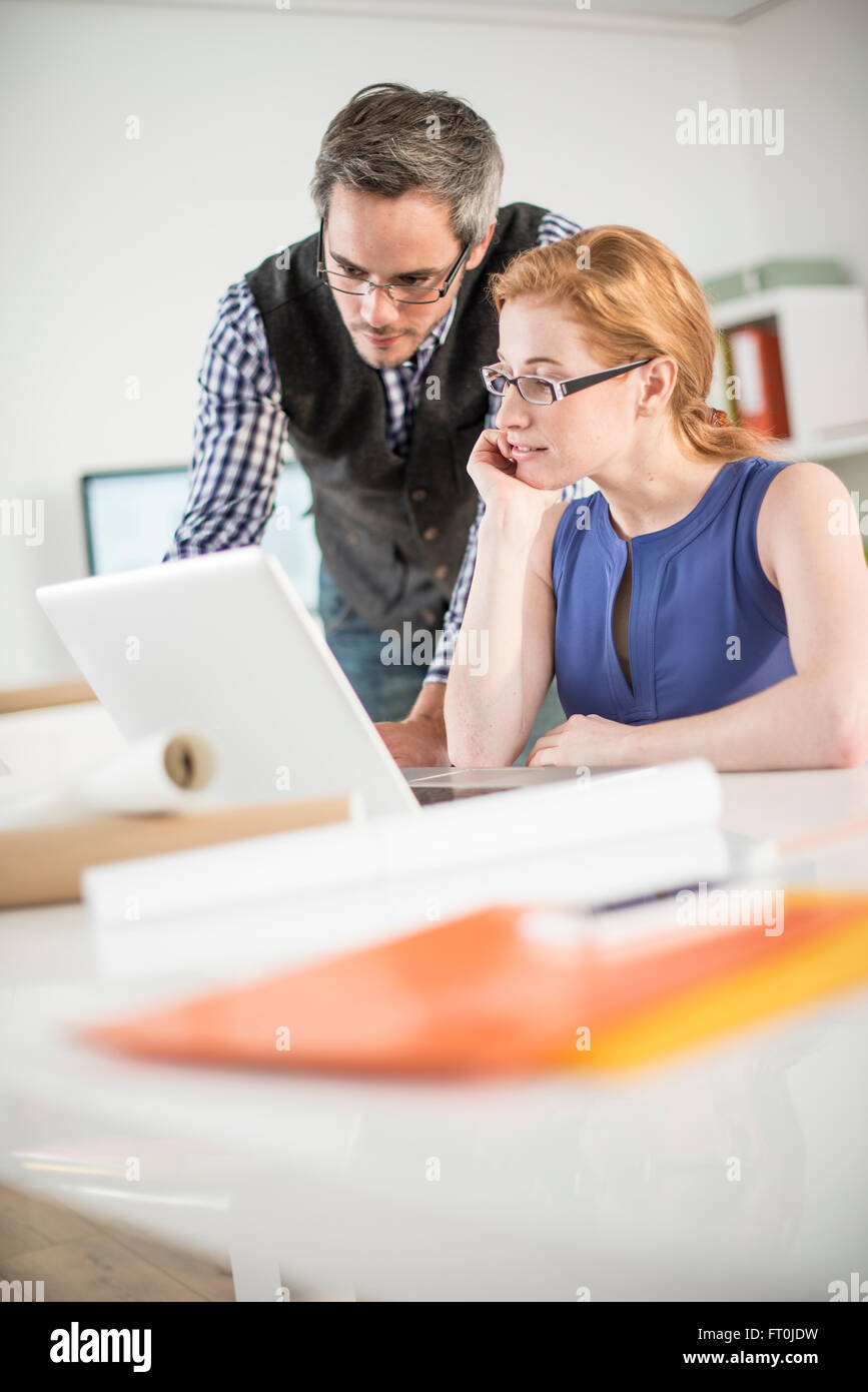 team discusses about a work project around a computer Stock Photo - Alamy