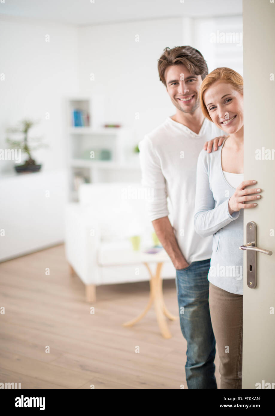 Cheerful couple inviting people enter hi-res stock photography and ...