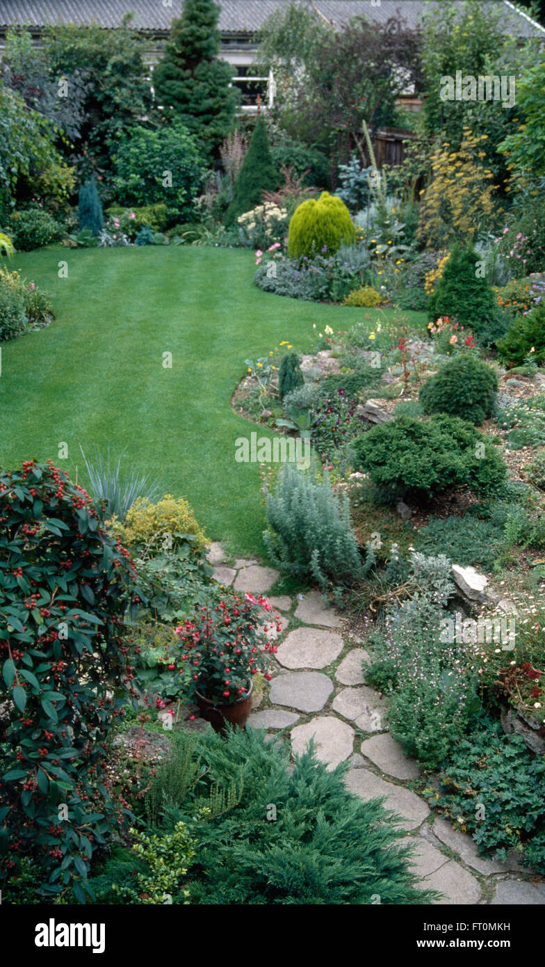 Birds-eye view of a crazy paved path to lawn edged with borders of ...