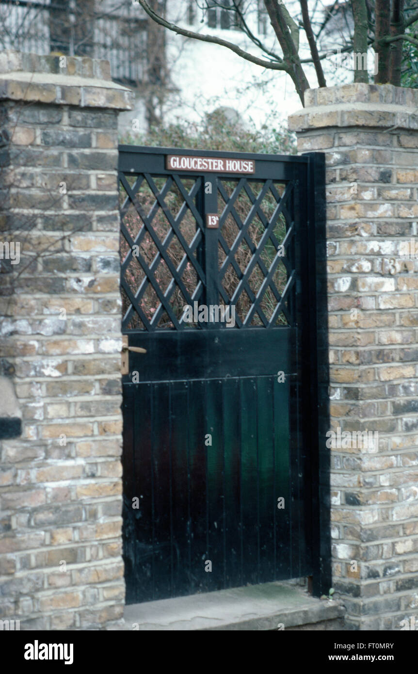 Close-up of a black painted front gate in a brick wall Stock Photo - Alamy