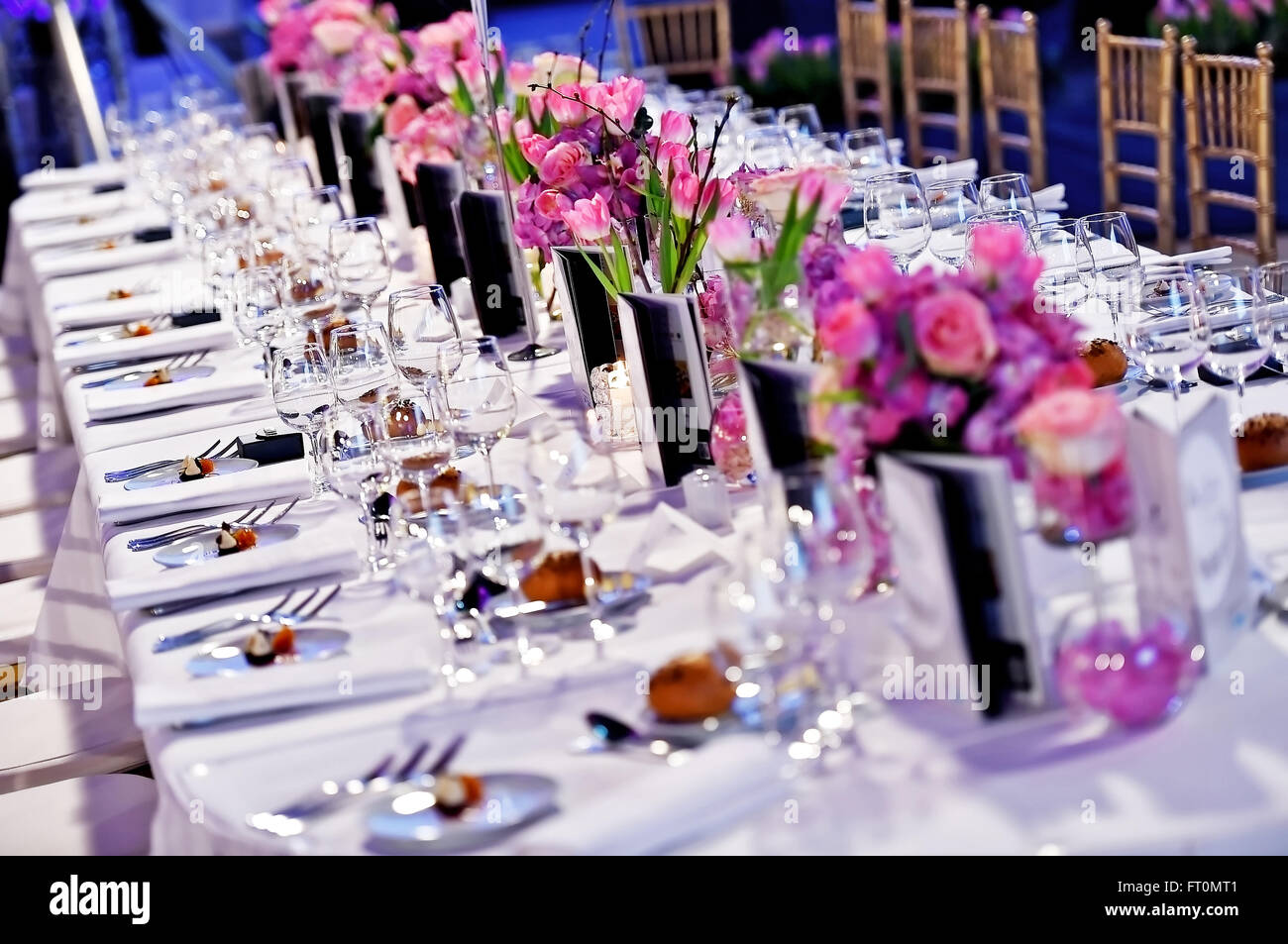 Festive dinner table with flowers bouquets and starters inside a ...